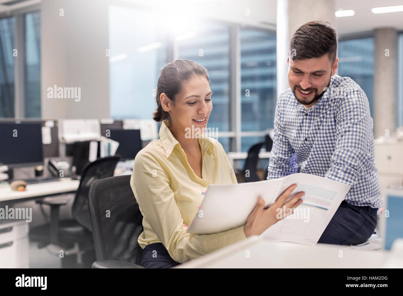 Business people reviewing paperwork in office Stock Photo - Alamy