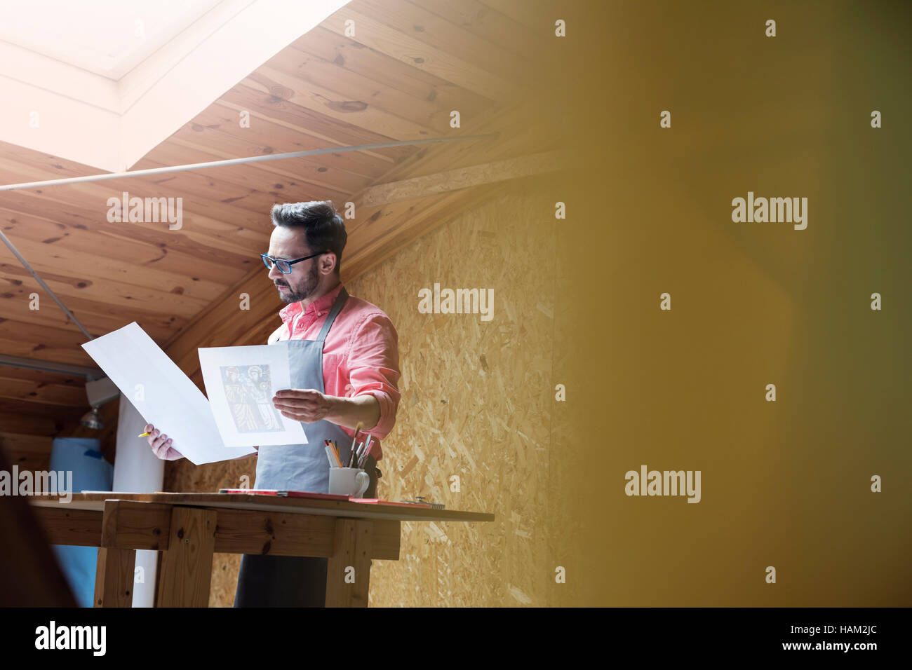 Artist reviewing drawings in studio Stock Photo - Alamy
