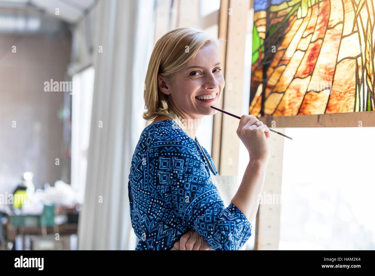 Portrait smiling artist working on stained glass Stock Photo - Alamy