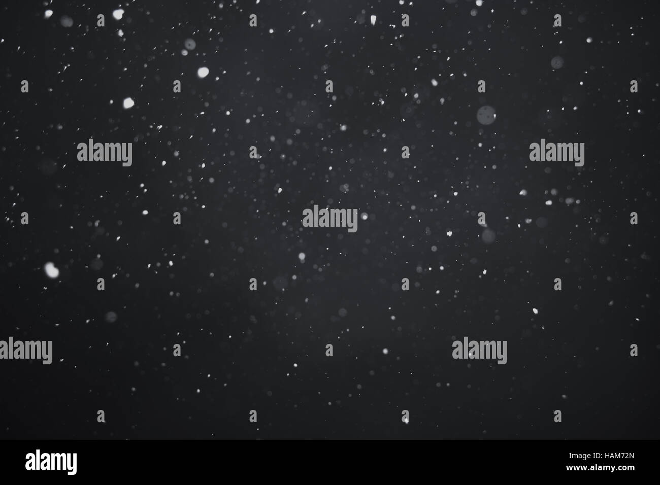 Falling snow on black background Stock Photo - Alamy