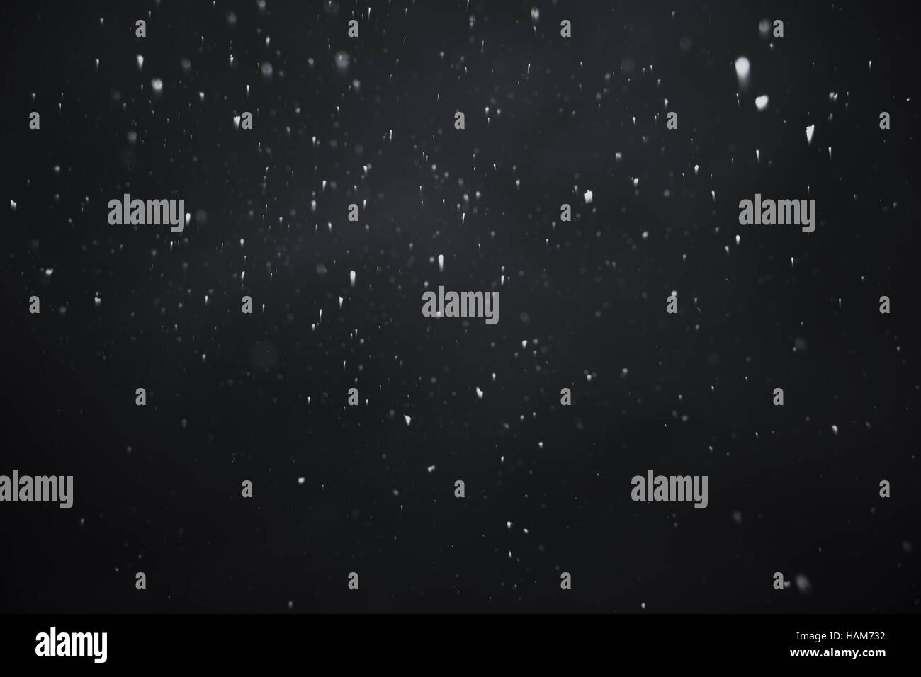 Falling snow on black background Stock Photo - Alamy
