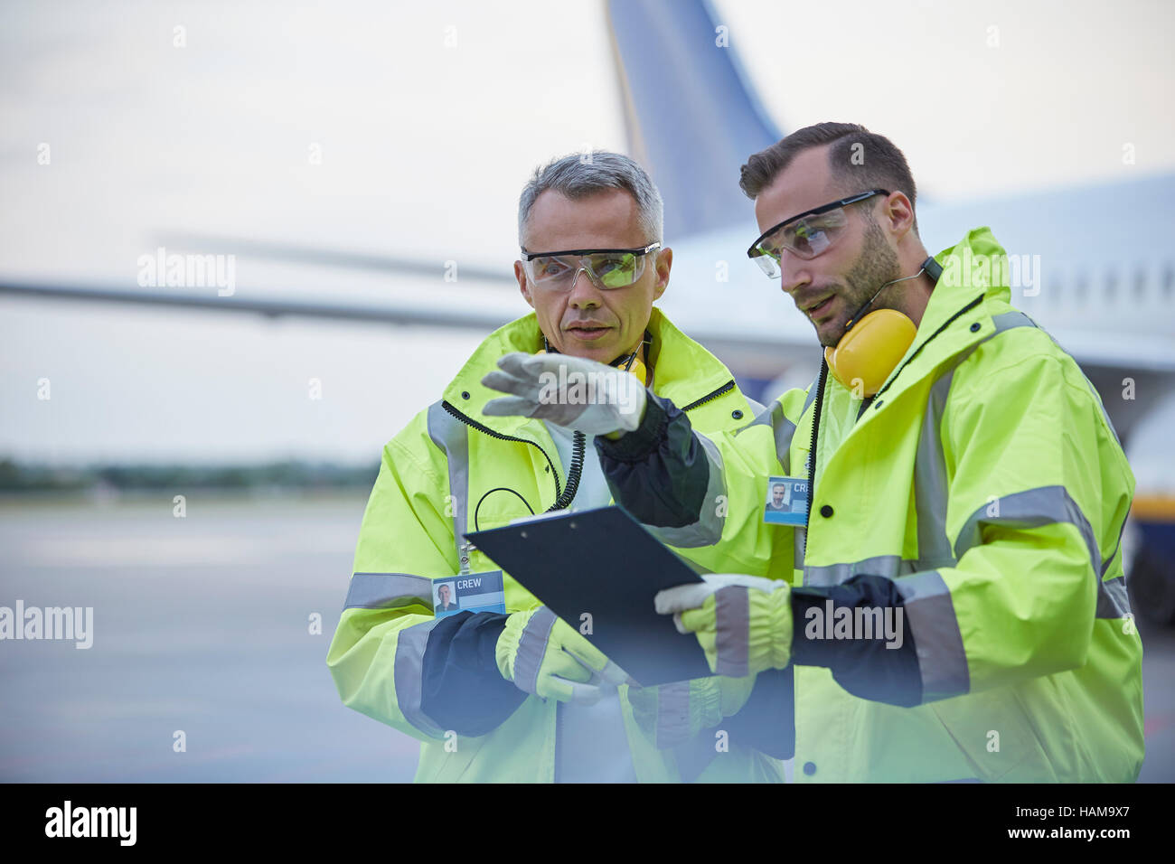 Air traffic control ground crew workers with clipboard talking on ...