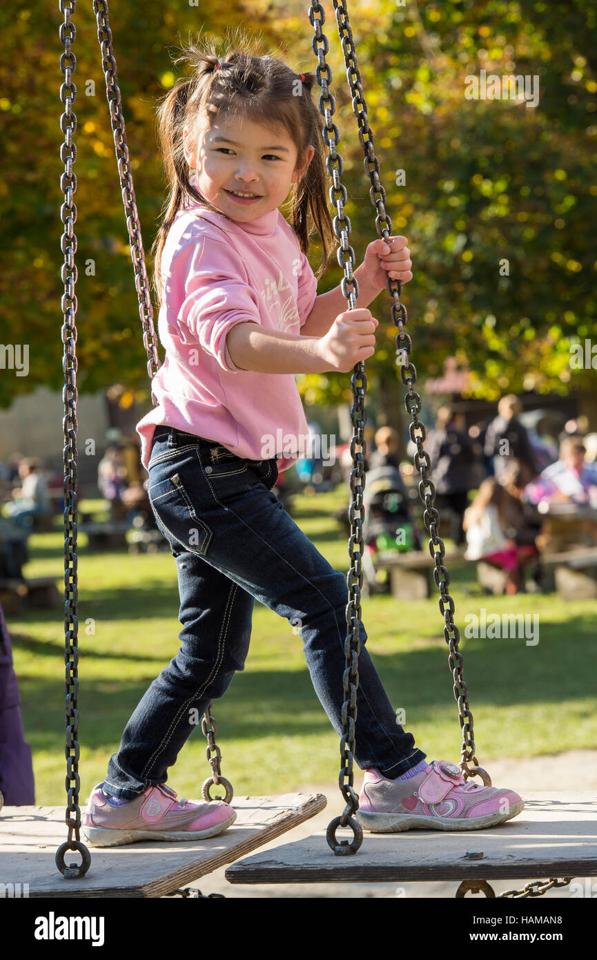 Eurasian girl standing on swing, Poing, Bavaria, Germany Stock Photo ...