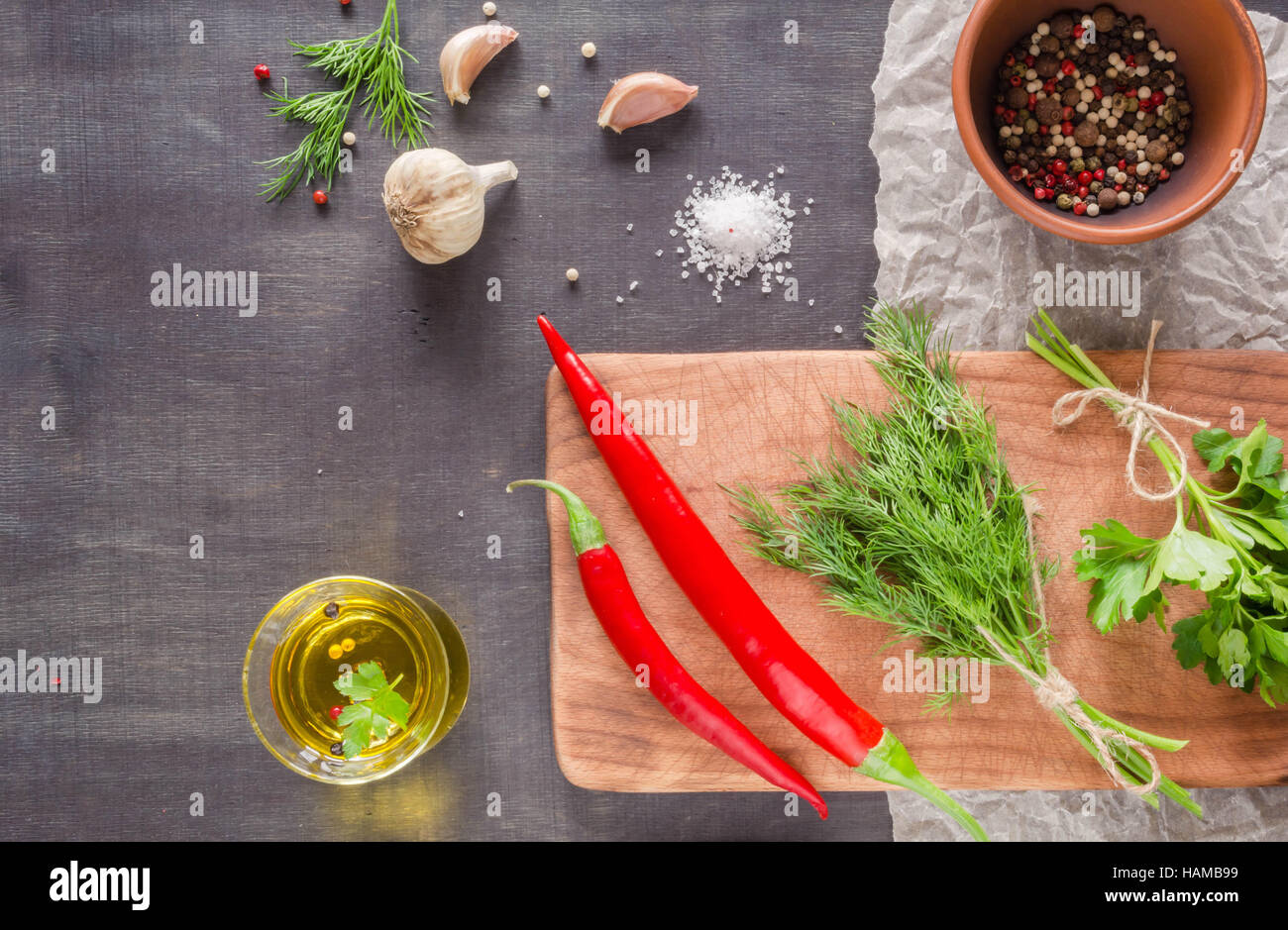 Parsley dill pepper and garlic in a dark wooden table. View from above ...