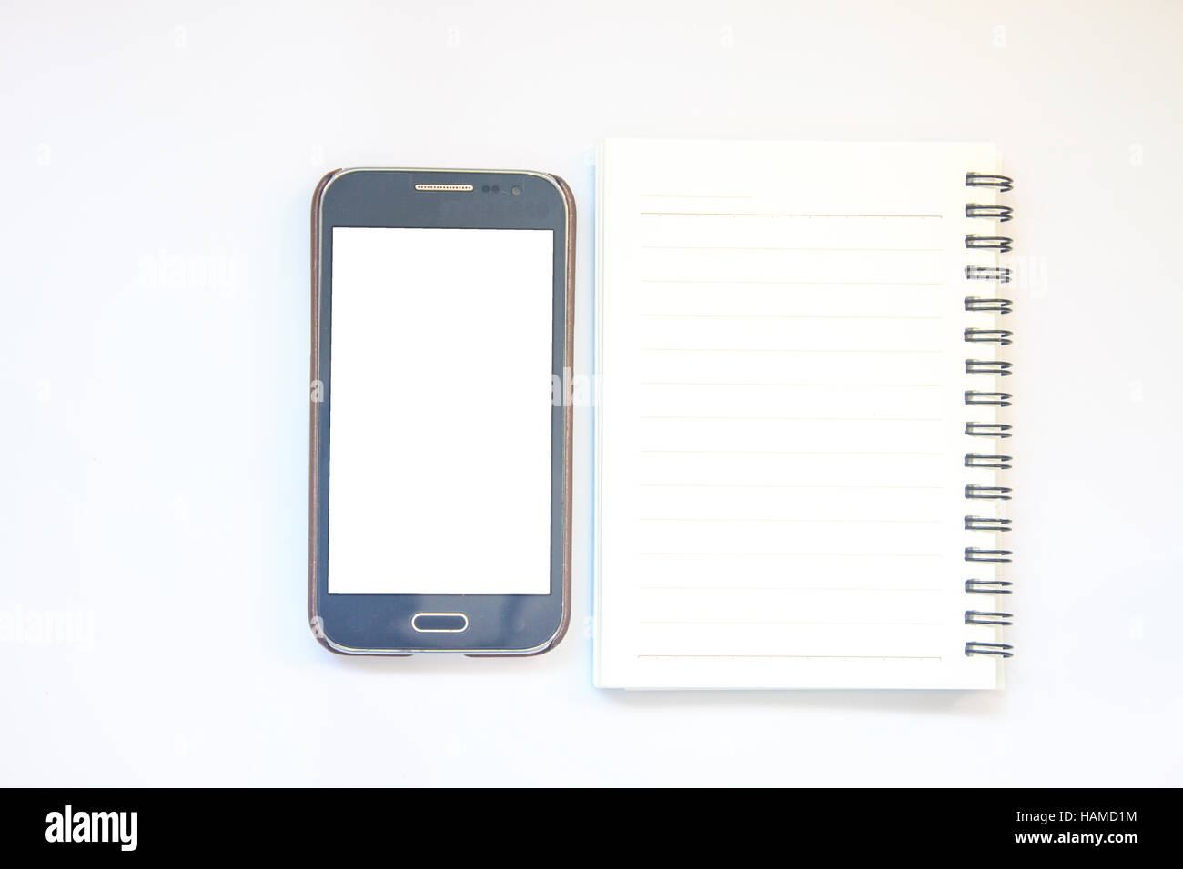 Opened notepad with smart phone on white background Stock Photo - Alamy