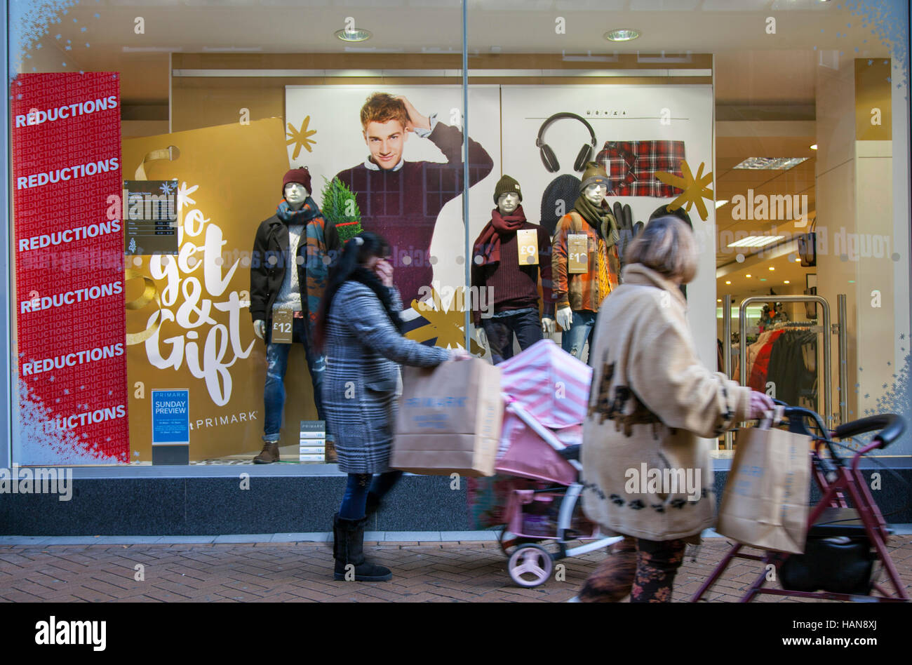 People passing Primark Sale reductions and Christmas window display ...