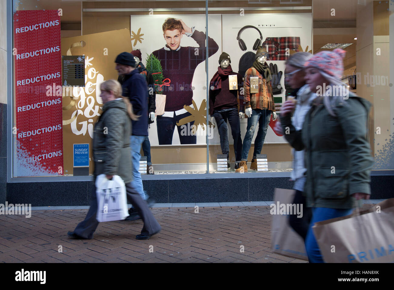 People passing Primark Sale reductions and Christmas window display ...
