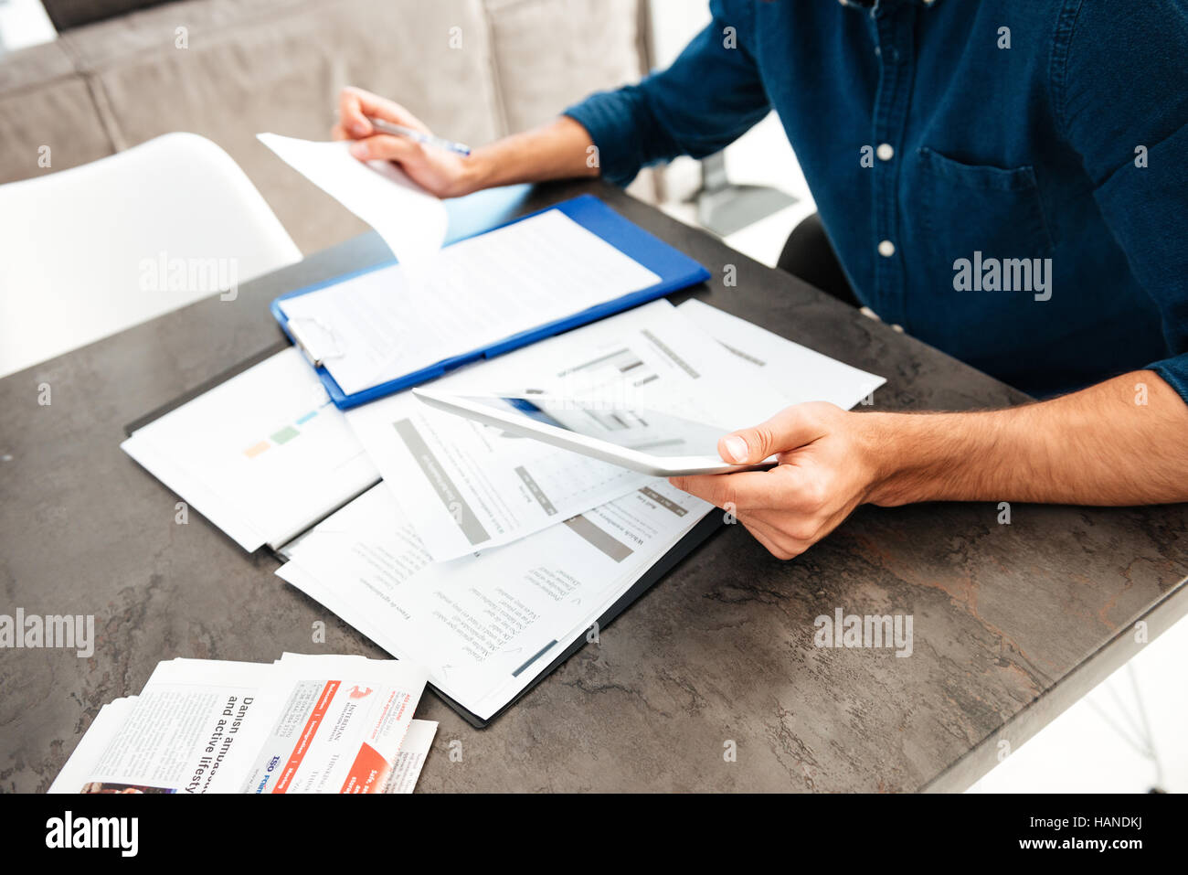 Cropped picture of young man's hands holding documents. Focus on hands ...