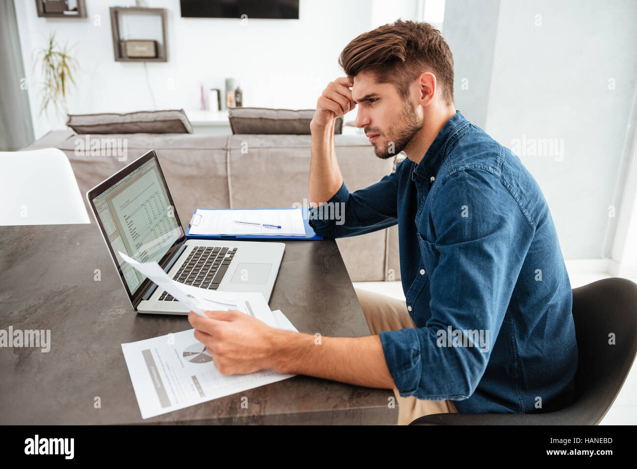 Picture of serious concentrated man working at laptop and sitting at ...