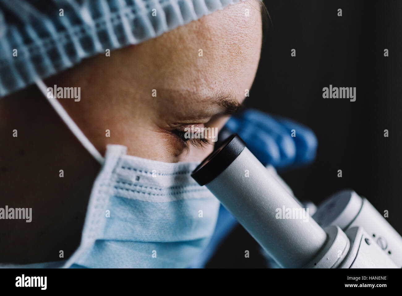 Female scientist looking at microscope Stock Photo - Alamy