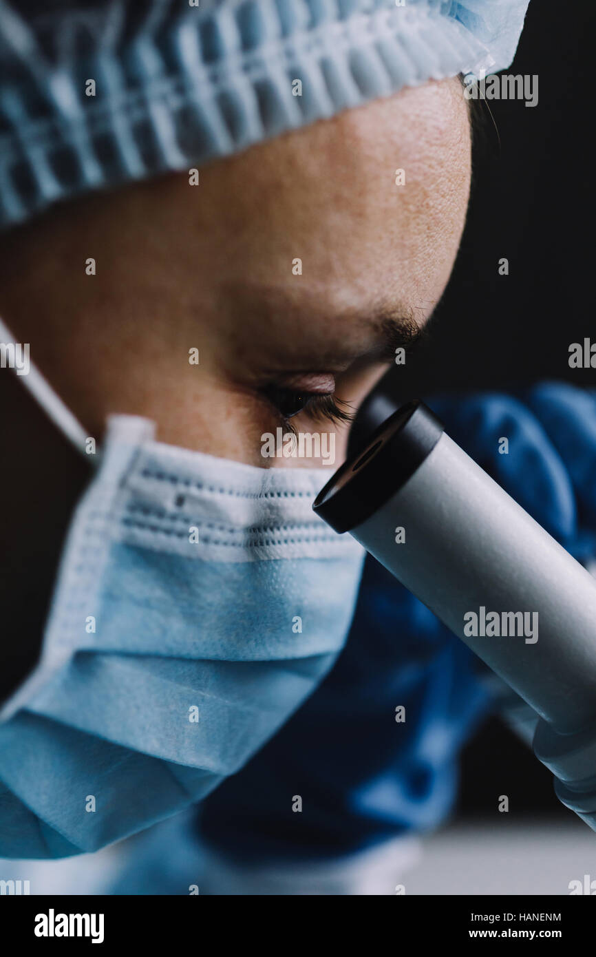 Female scientist looking at microscope Stock Photo - Alamy