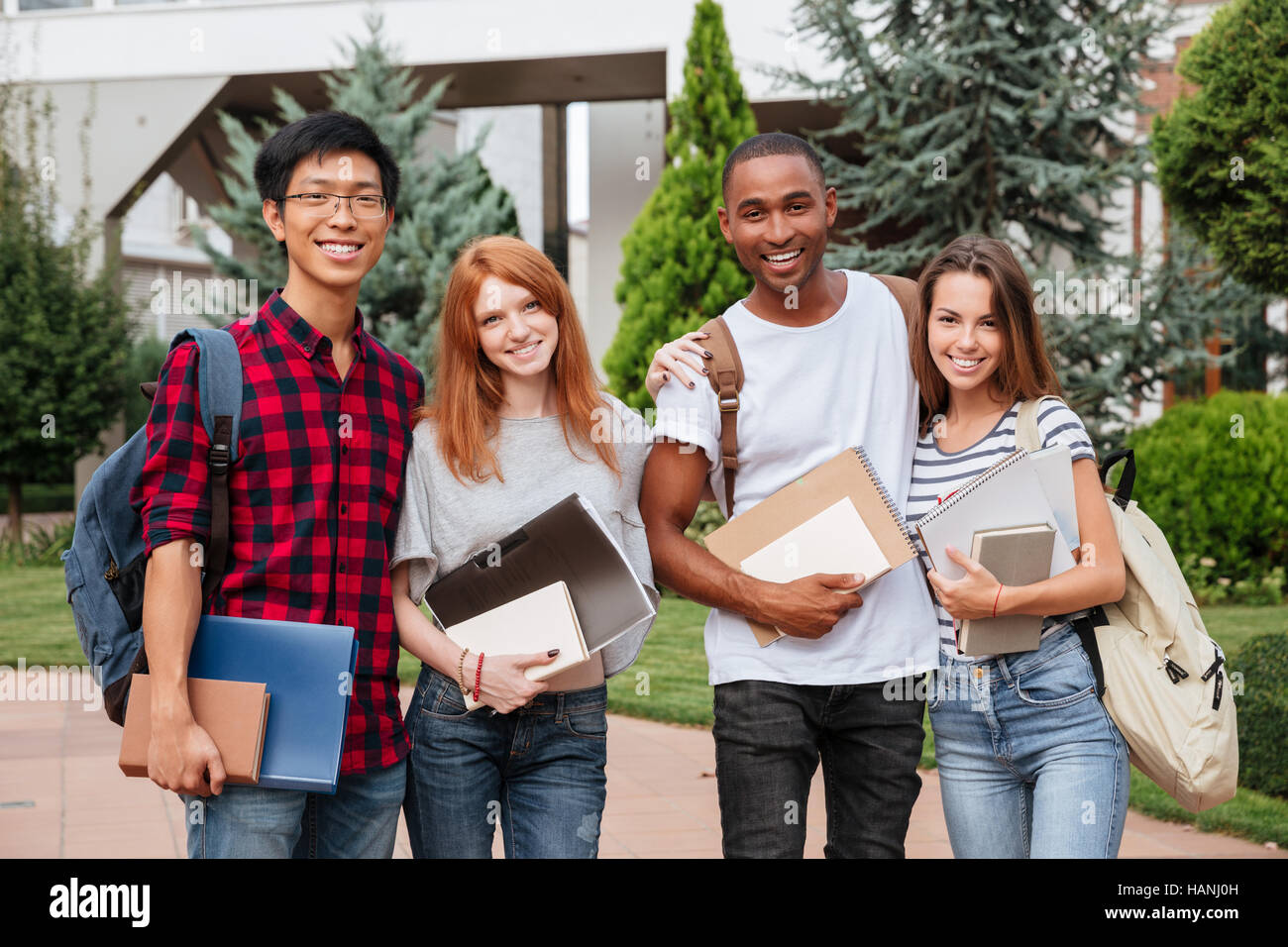 Multiethnic group of cheerful young students standing together outdoors Stock Photo - Alamy