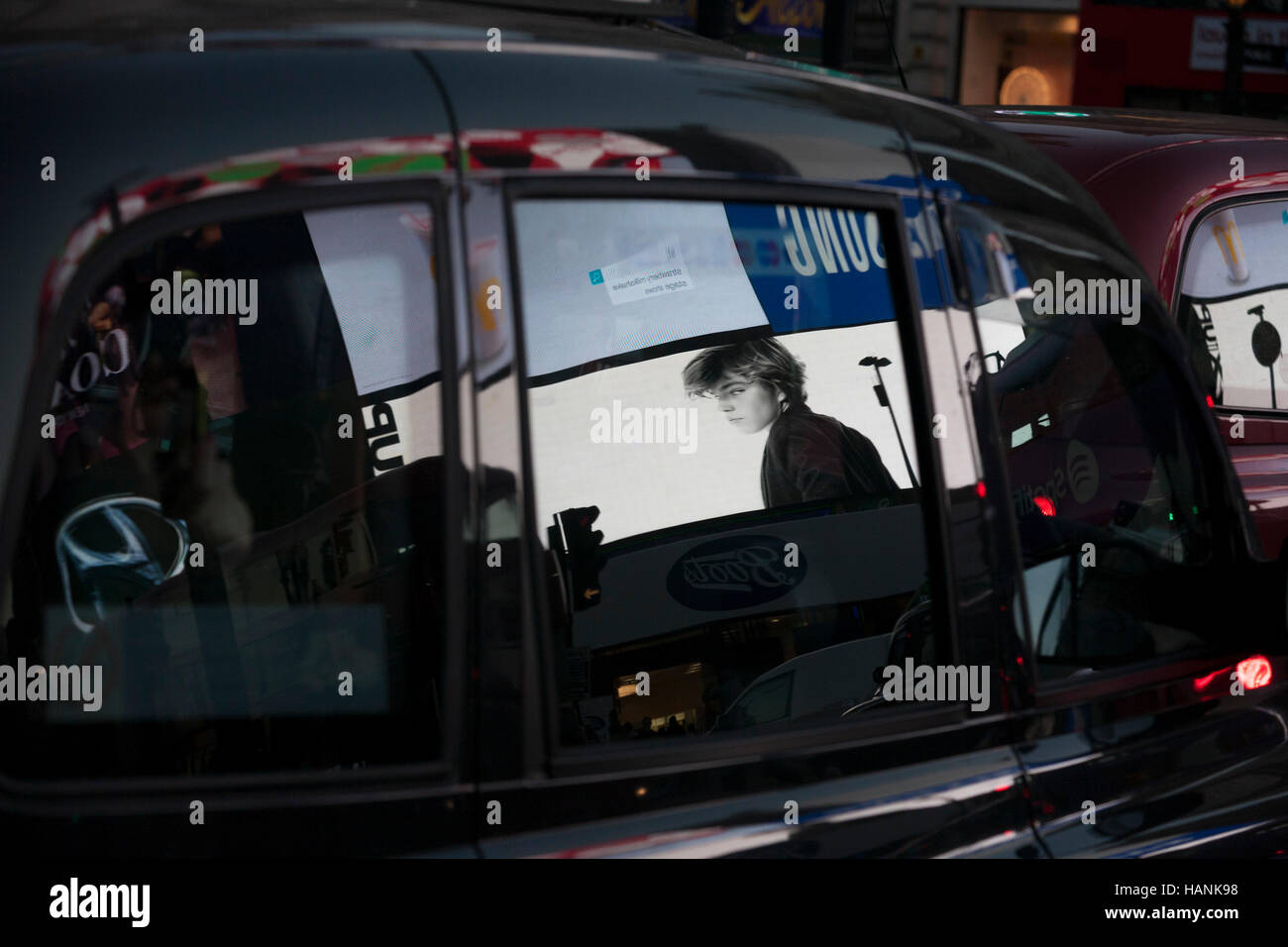 Advertising reflected in taxi windows at dusk in Piccadilly Circus, on ...
