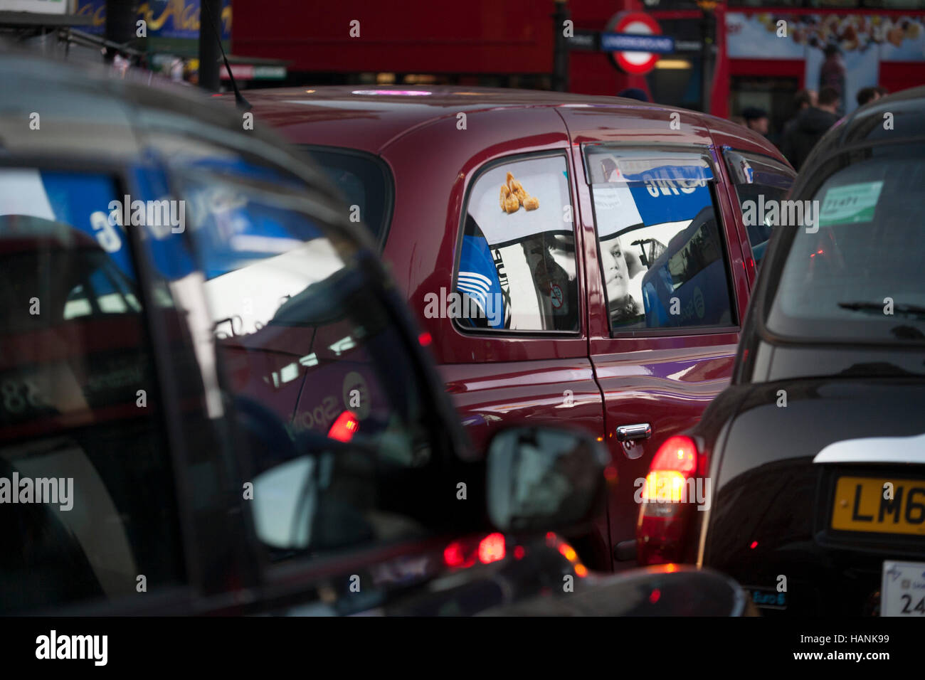 Advertising reflected in taxi windows at dusk in Piccadilly Circus, on ...