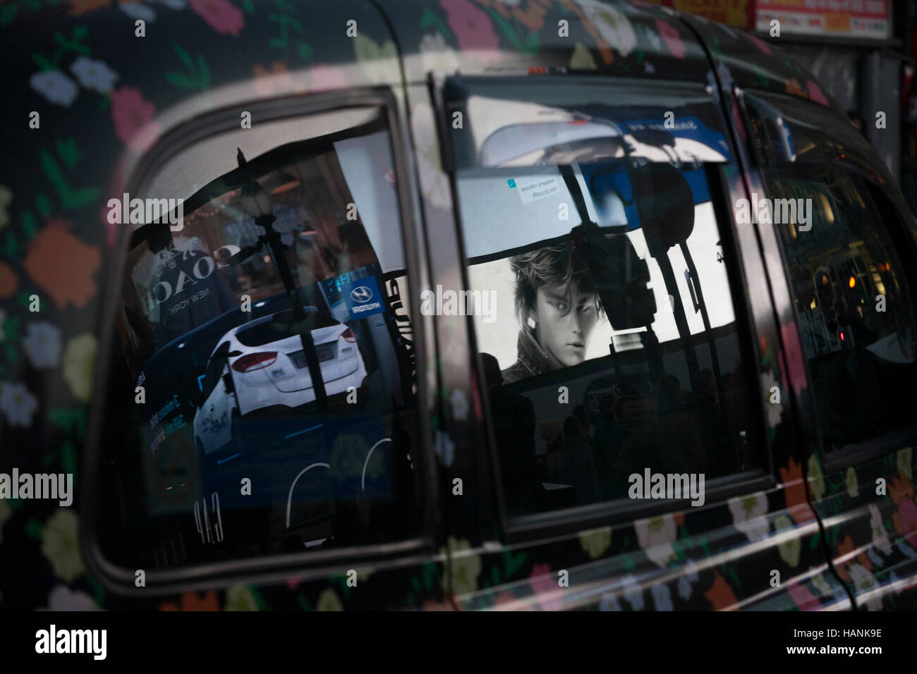 Advertising reflected in taxi windows at dusk in Piccadilly Circus, on ...