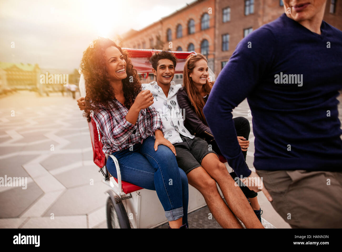 Group of friends having fun on tricycle ride in the city. Young people ...