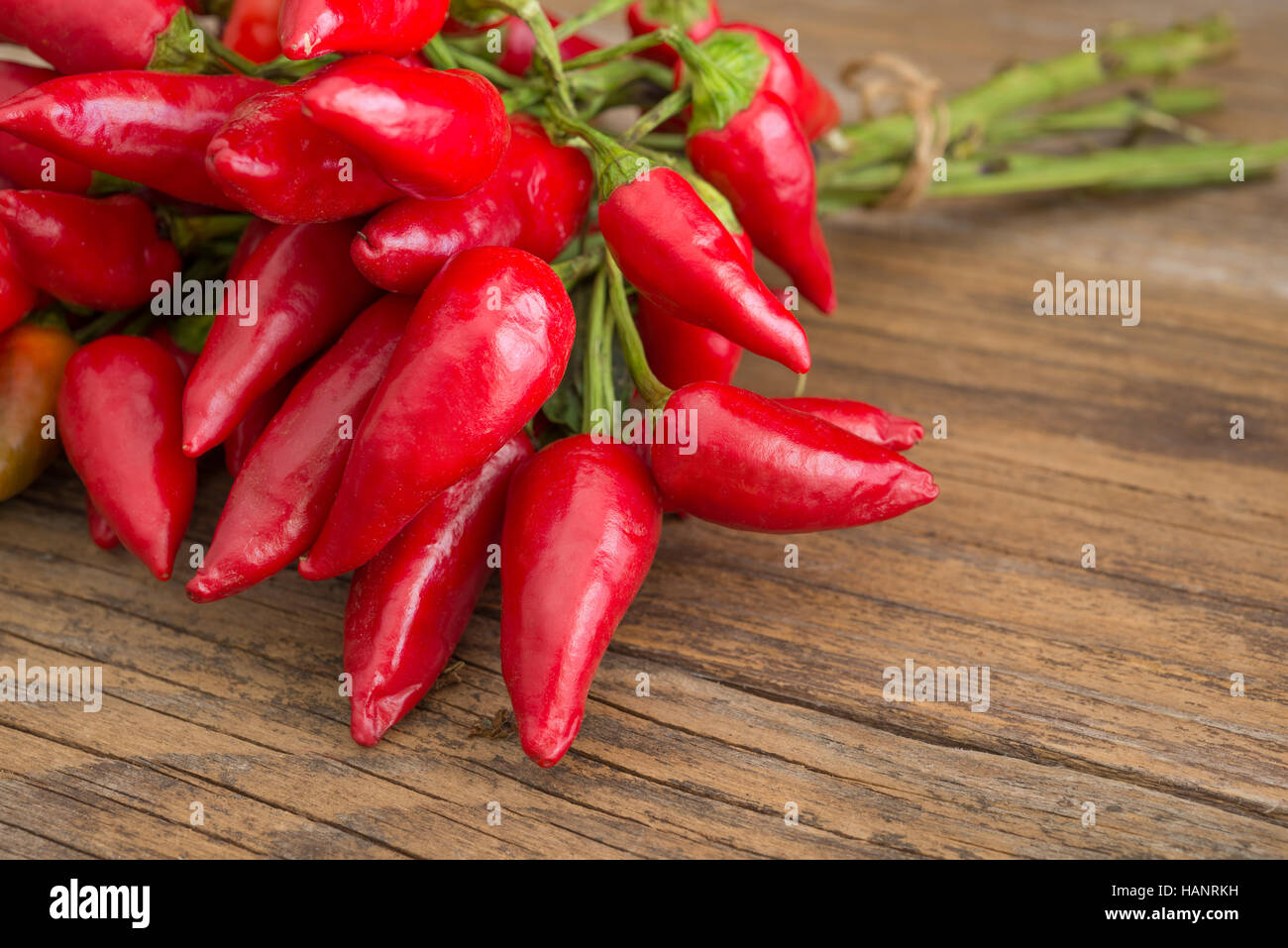 Bunch of red hot chili pepper on wooden table Stock Photo - Alamy