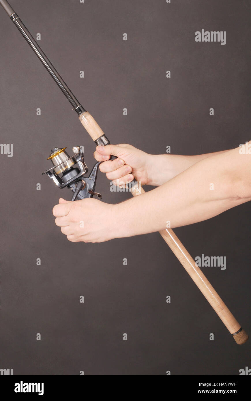 Man's hand holding a fishing rod on a black background Stock Photo - Alamy
