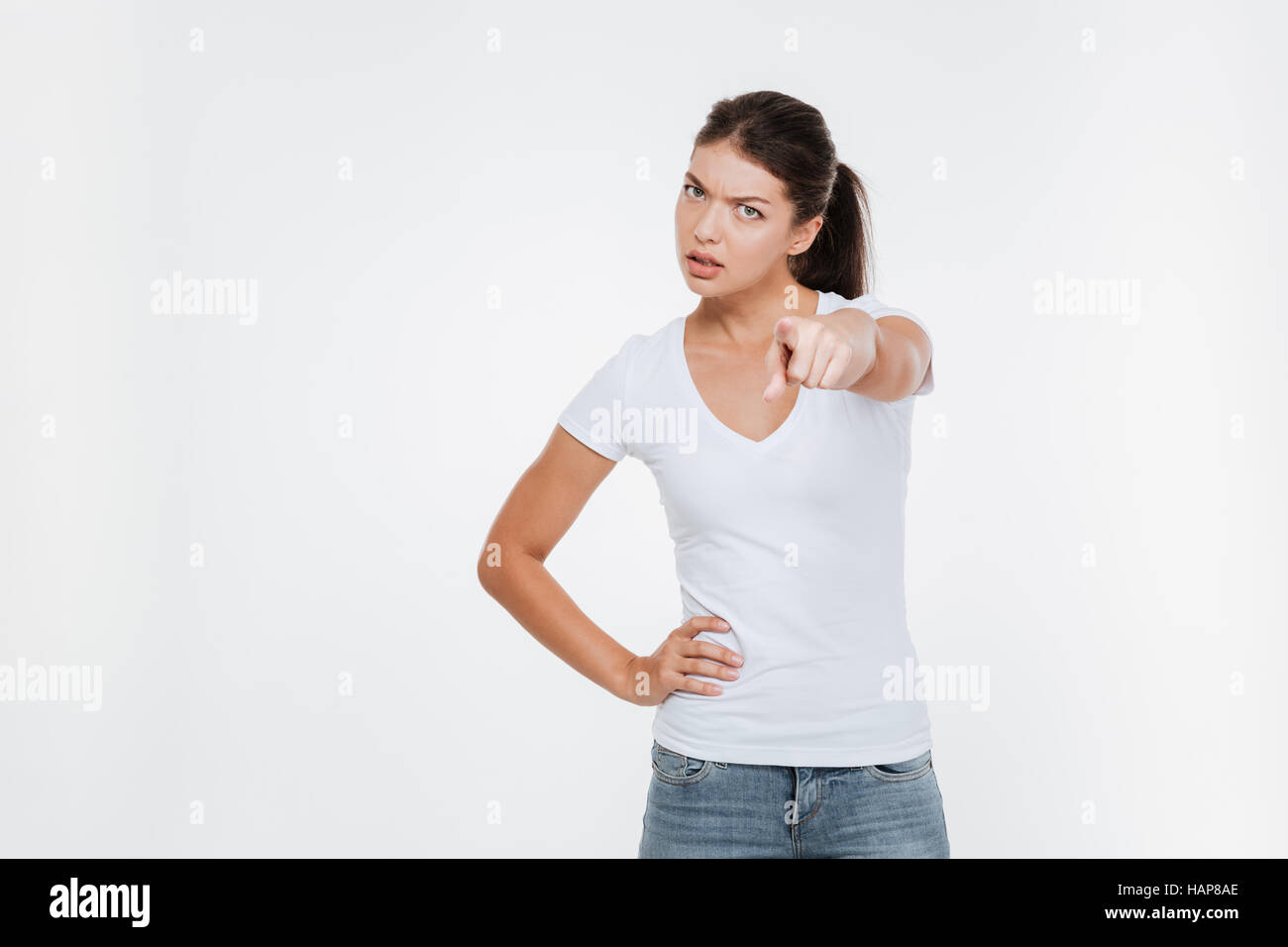 Serious model in t-shirt showing at camera. isolated white background ...