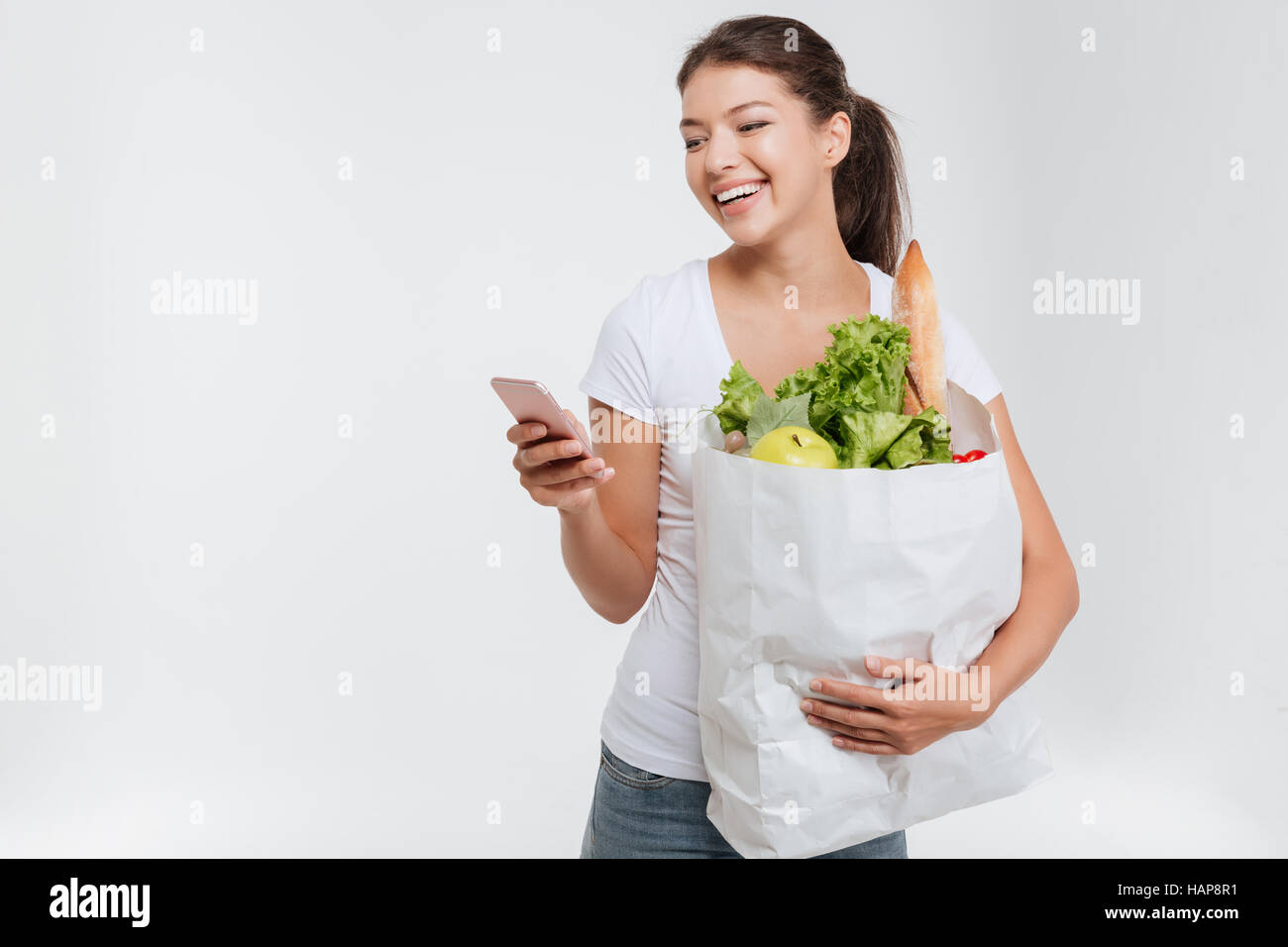 Model with food in package and phone. In studio. Isolated white ...