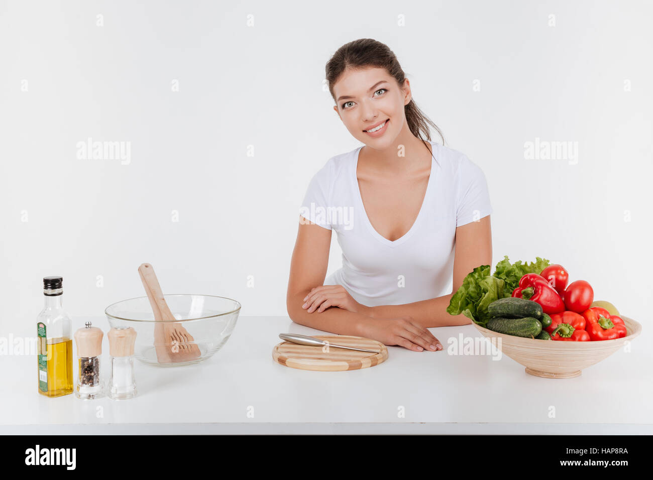 Model sitting by the table with with food. Looking at camera. Isolated ...