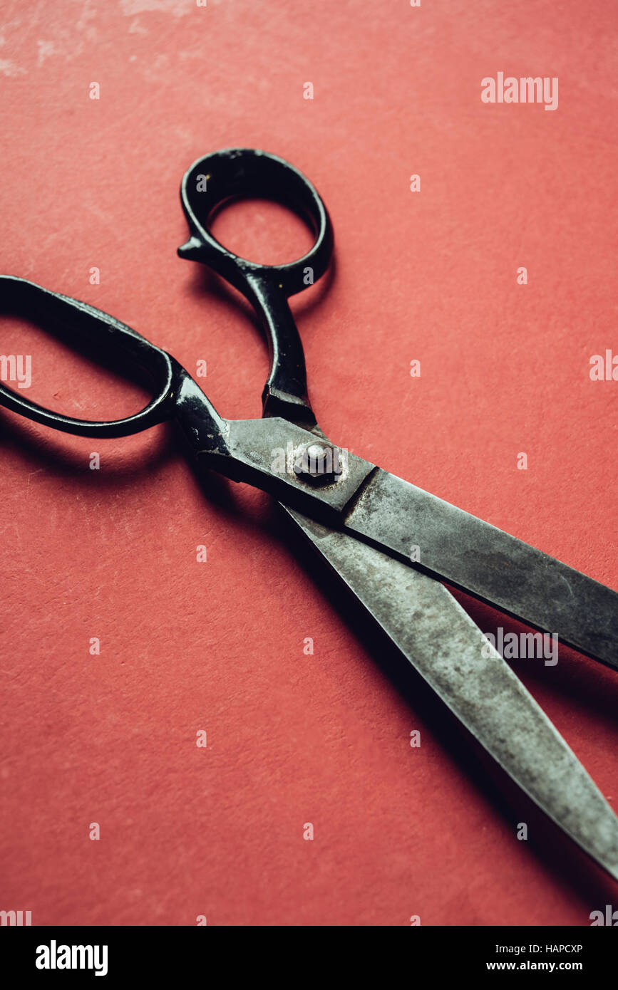 Tailor's scissors on a red background Stock Photo - Alamy