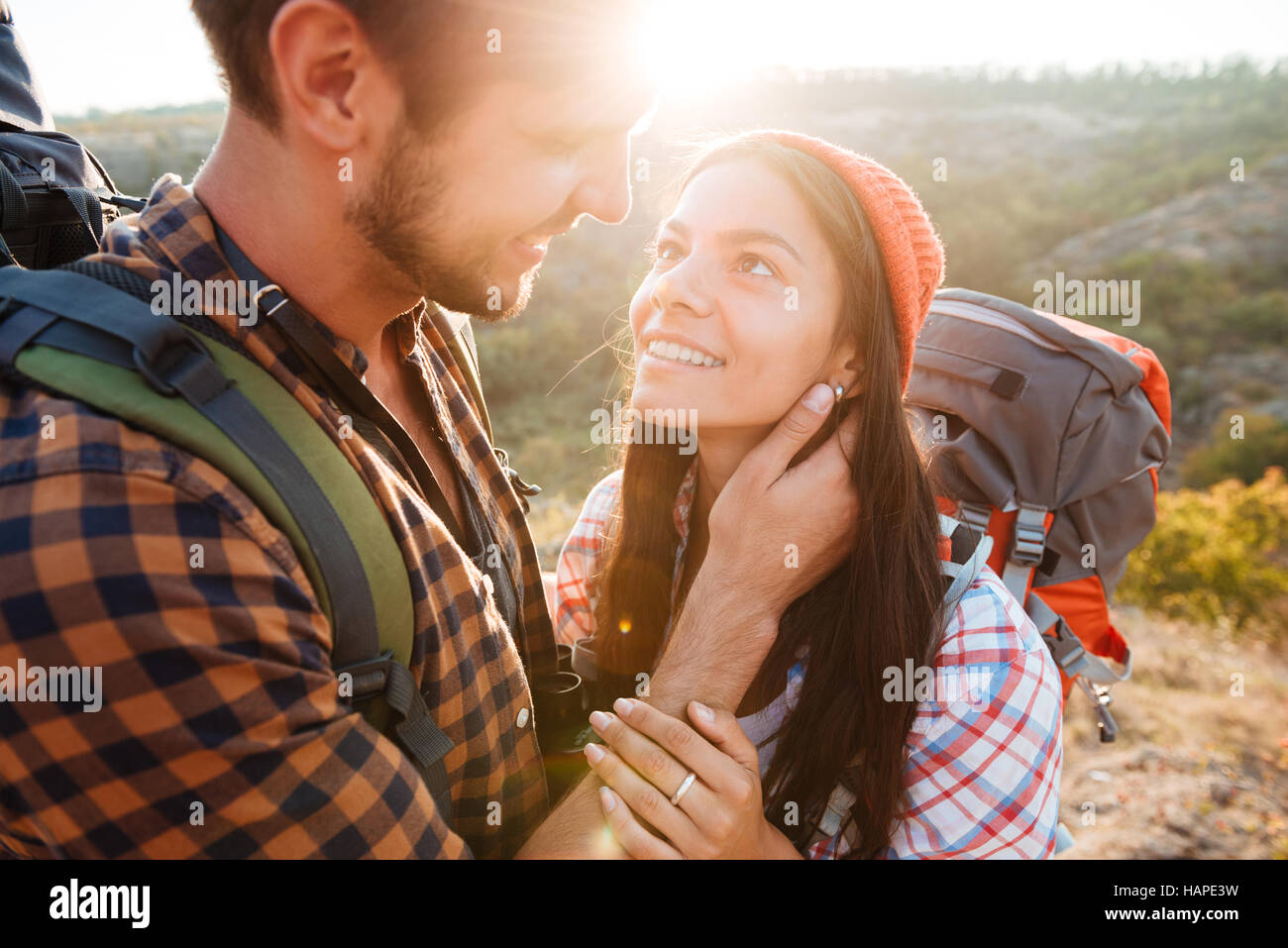 Attractive couple with backpacks in the mountains. eyes to eyes Stock ...