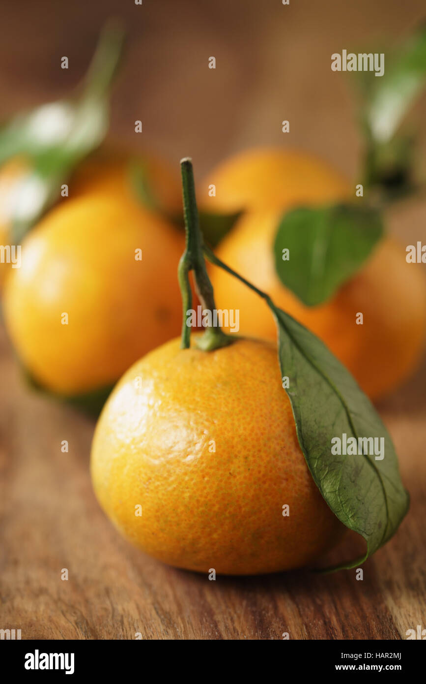 organic fresh tangerines with leaves on wooden table Stock Photo - Alamy