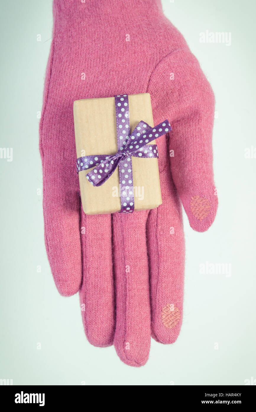 Vintage photo, Hand of woman in pink woolen gloves and wrapped gift for ...