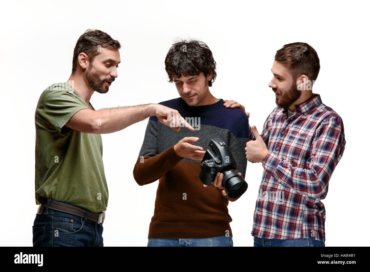 The three male friends with camera on white studio background Stock ...