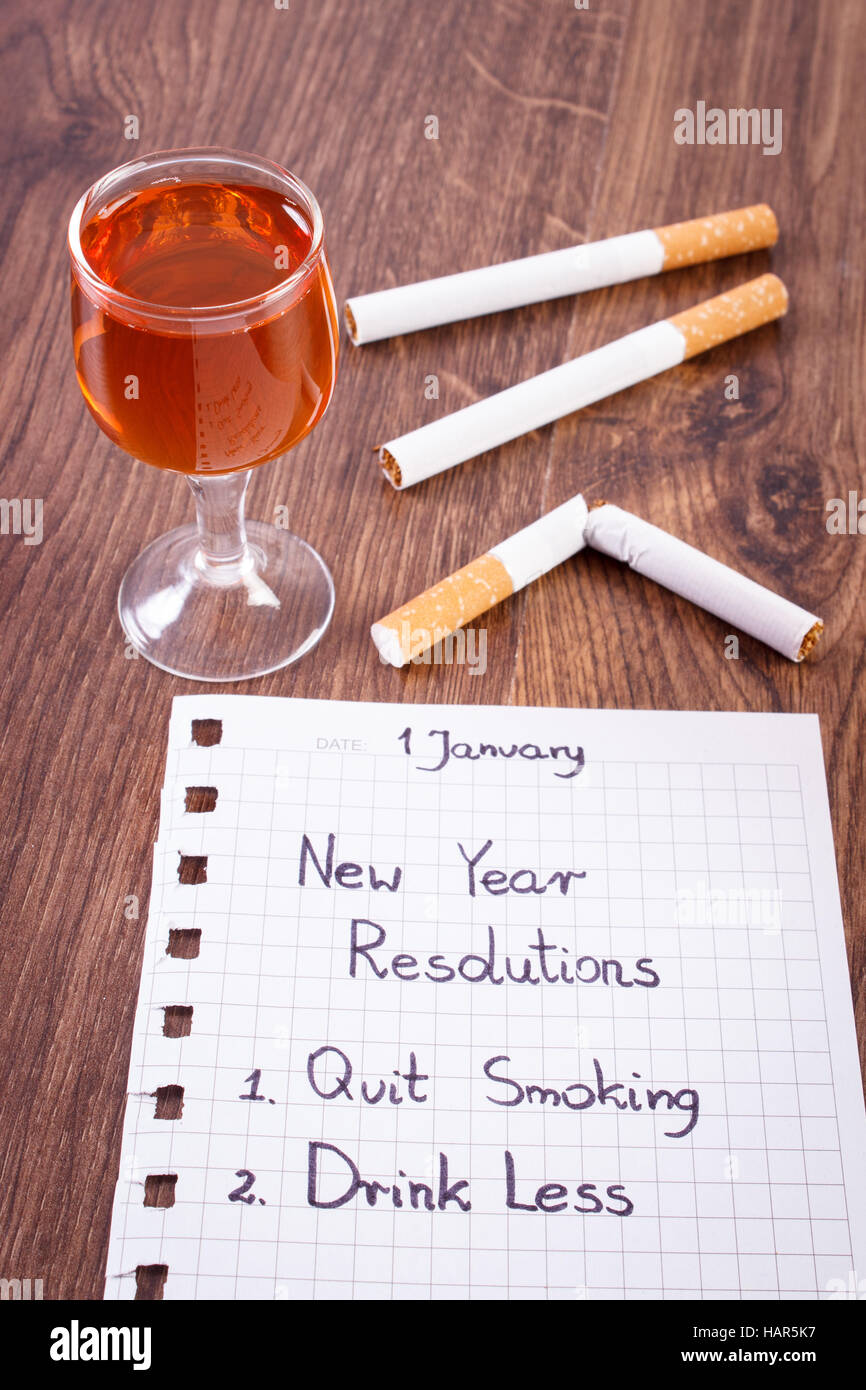 New years resolutions quit smoking and drink less written on sheet of ...