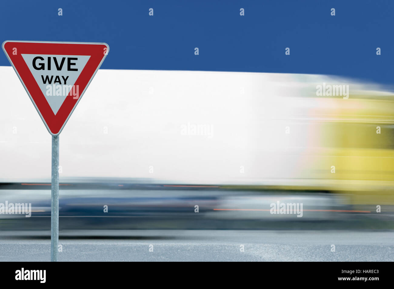 Give way yield road traffic sign and motion blurred truck in the ...