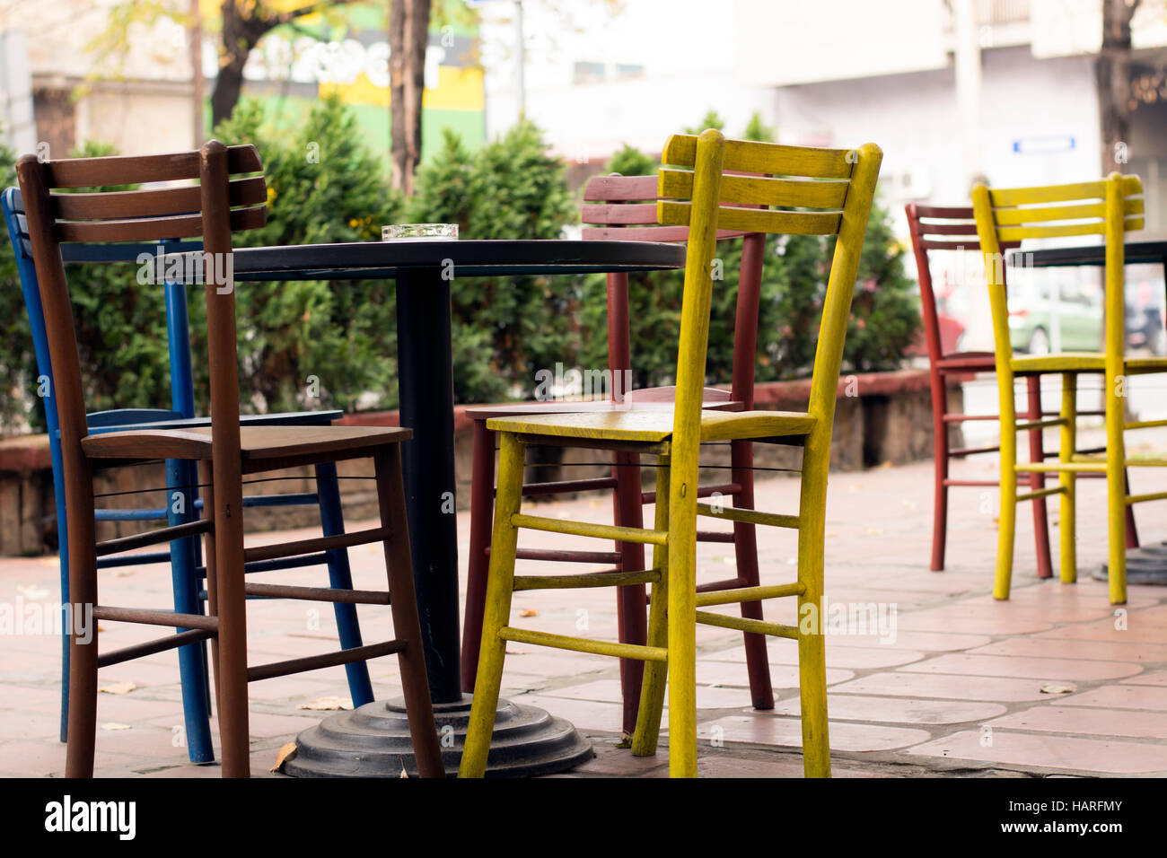 Colourful tables and chairs in a cafe garden Stock Photo - Alamy