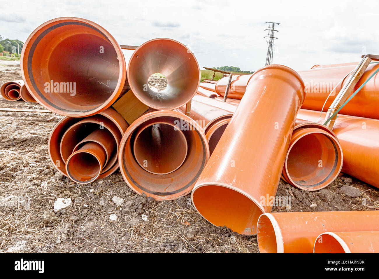 Arranged sewer pipes are waiting to be placed into the ditch at ...