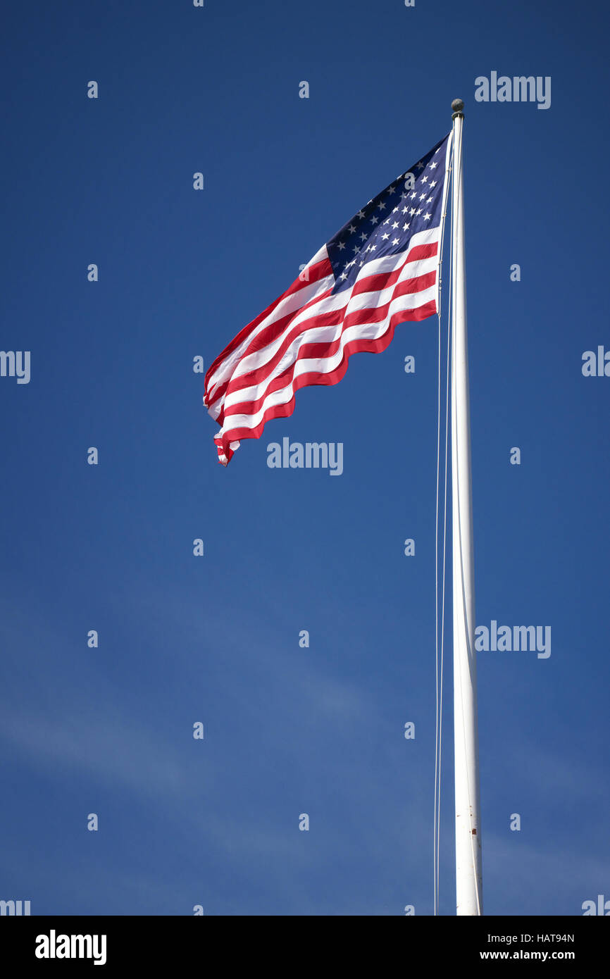 American Flag flying against bright blue sky Stock Photo - Alamy