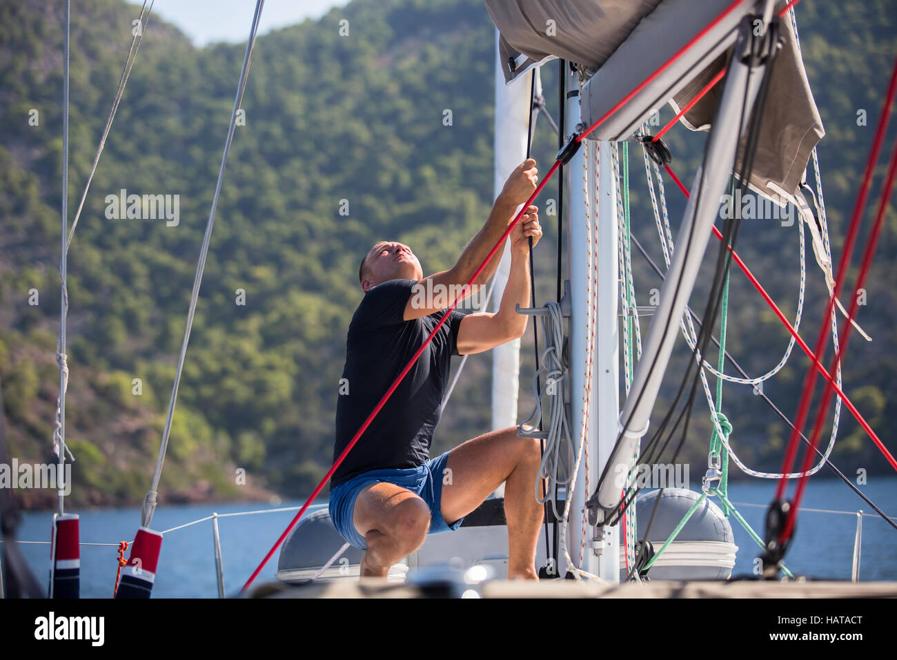 Man pulls the rope tuning the sails on the boat. Sailing ship during ...