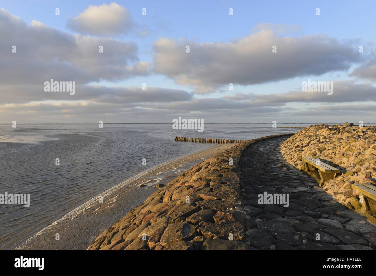 Wooden benches on the strong fixed waterside with rocks and concrete in ...