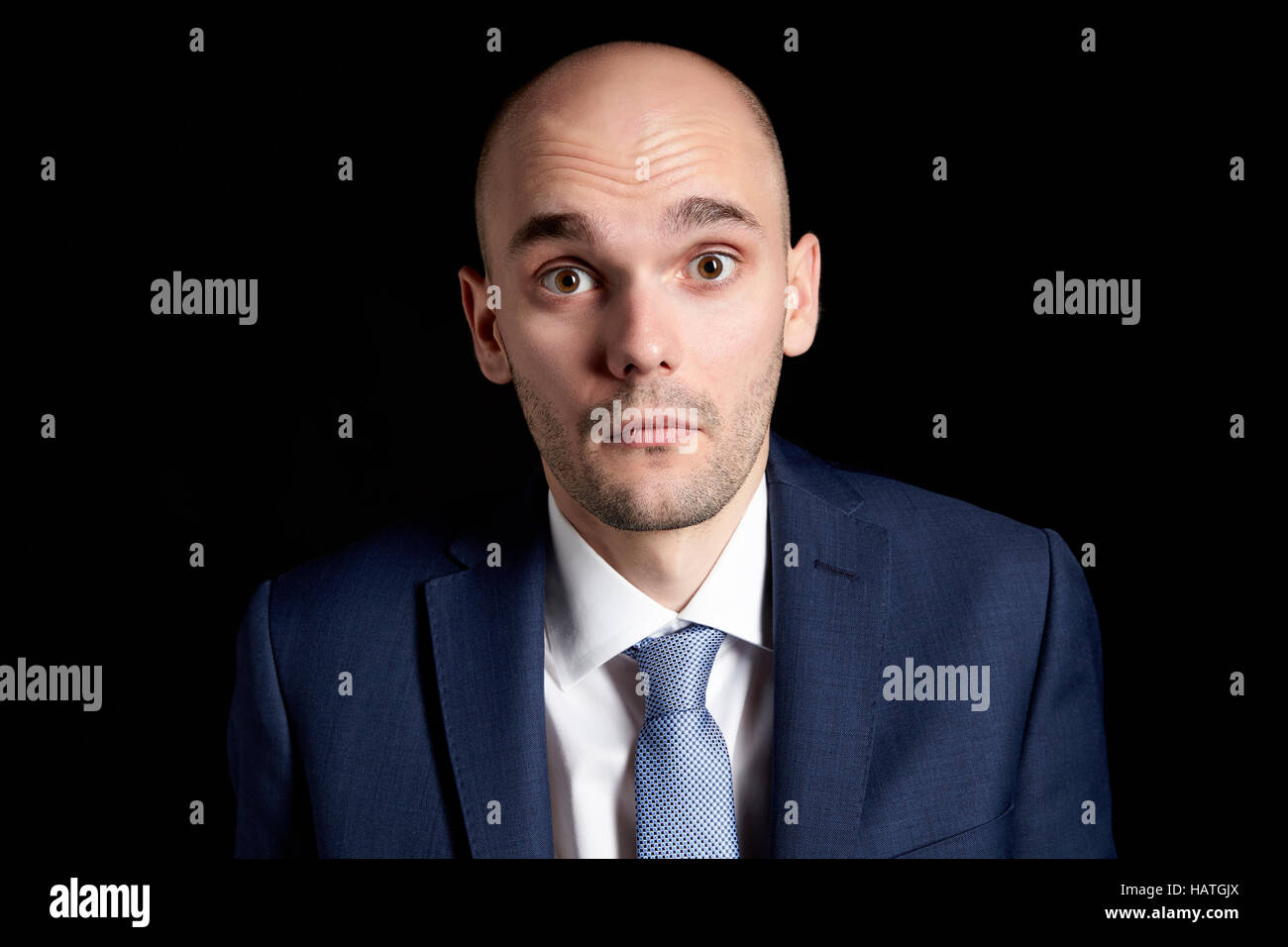 Studio shot of young scared businessman against black background Stock ...