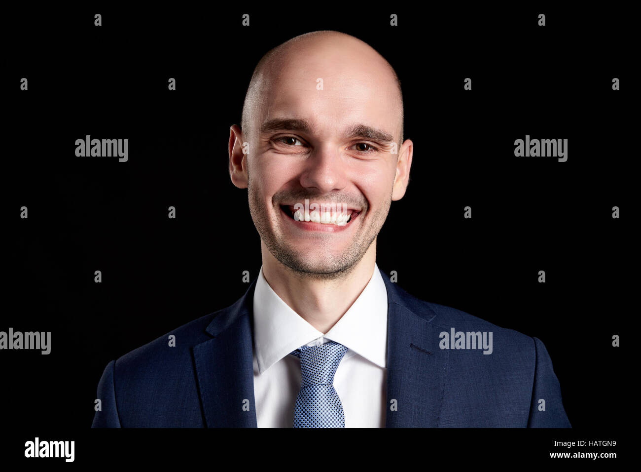Studio portrait of young goofy man against black background. Funny face ...