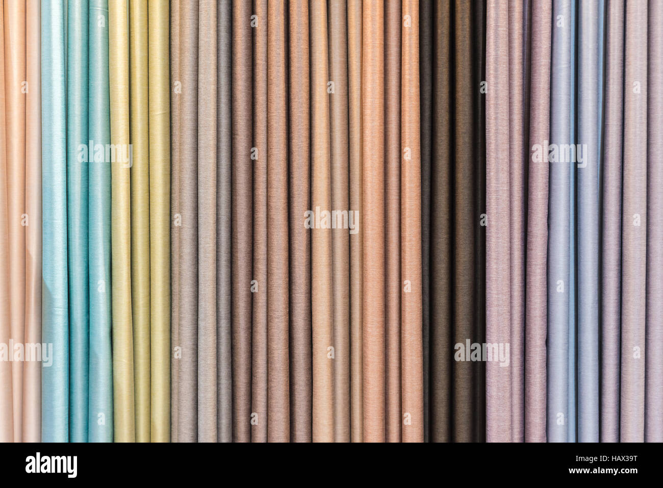Colorful curtain samples hanging from hangers on a rail in a display in ...