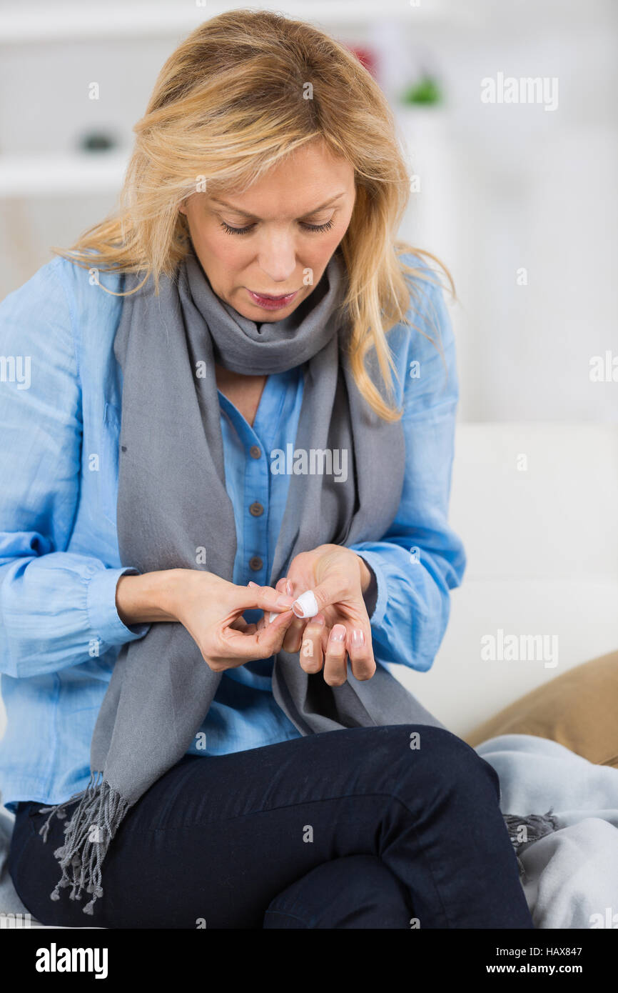 mature woman put plaster bandage on finger cut Stock Photo - Alamy