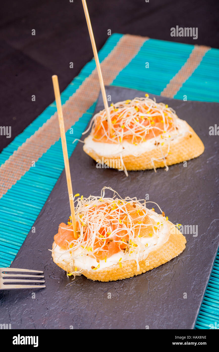 Pincho style salmon tapa served on goat cheese Stock Photo - Alamy