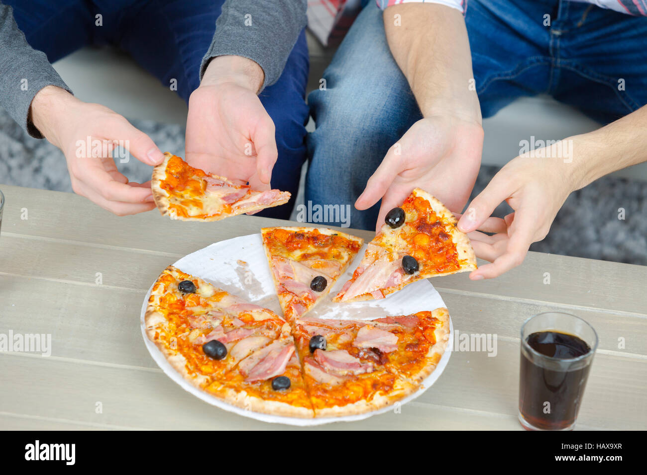 Friends sharing a pizza Stock Photo - Alamy
