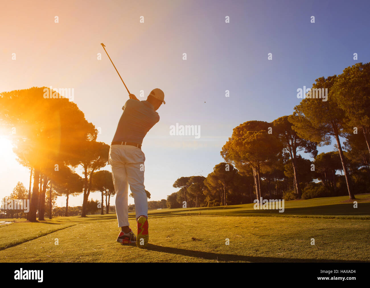 golf player hitting shot with club on course at beautiful morning with ...