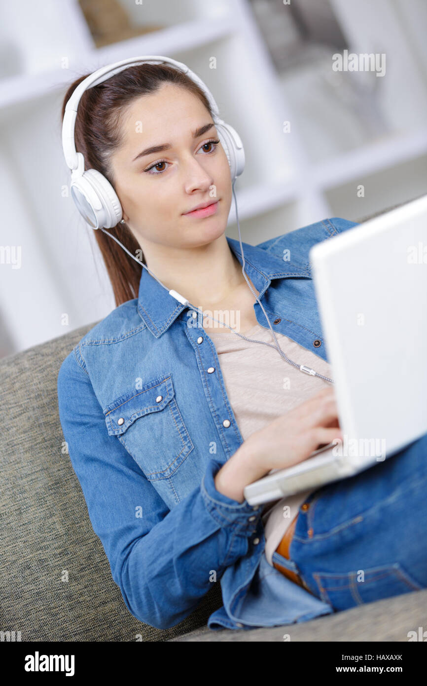 girl with laptop listening to music on the sofa Stock Photo - Alamy