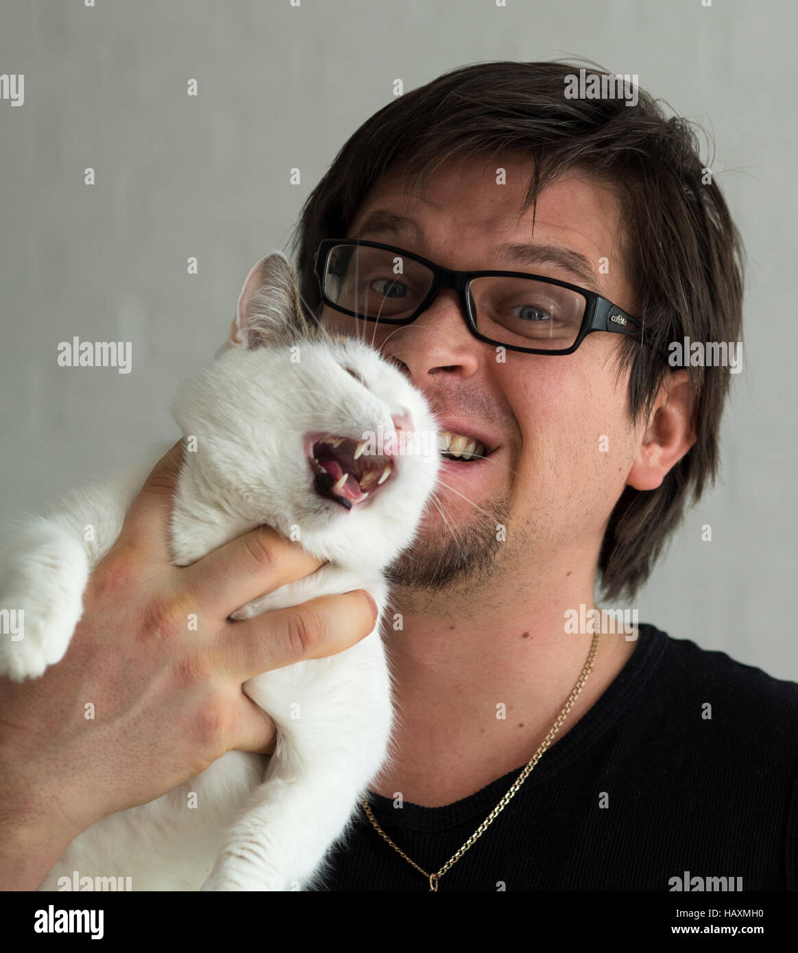 Young caucasian man holds cat. Real people Stock Photo - Alamy