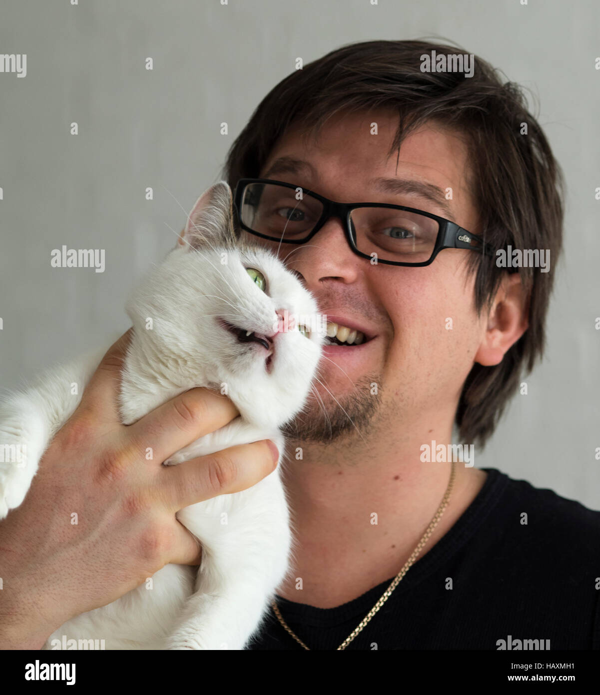 Young caucasian man holds cat. Real people Stock Photo - Alamy