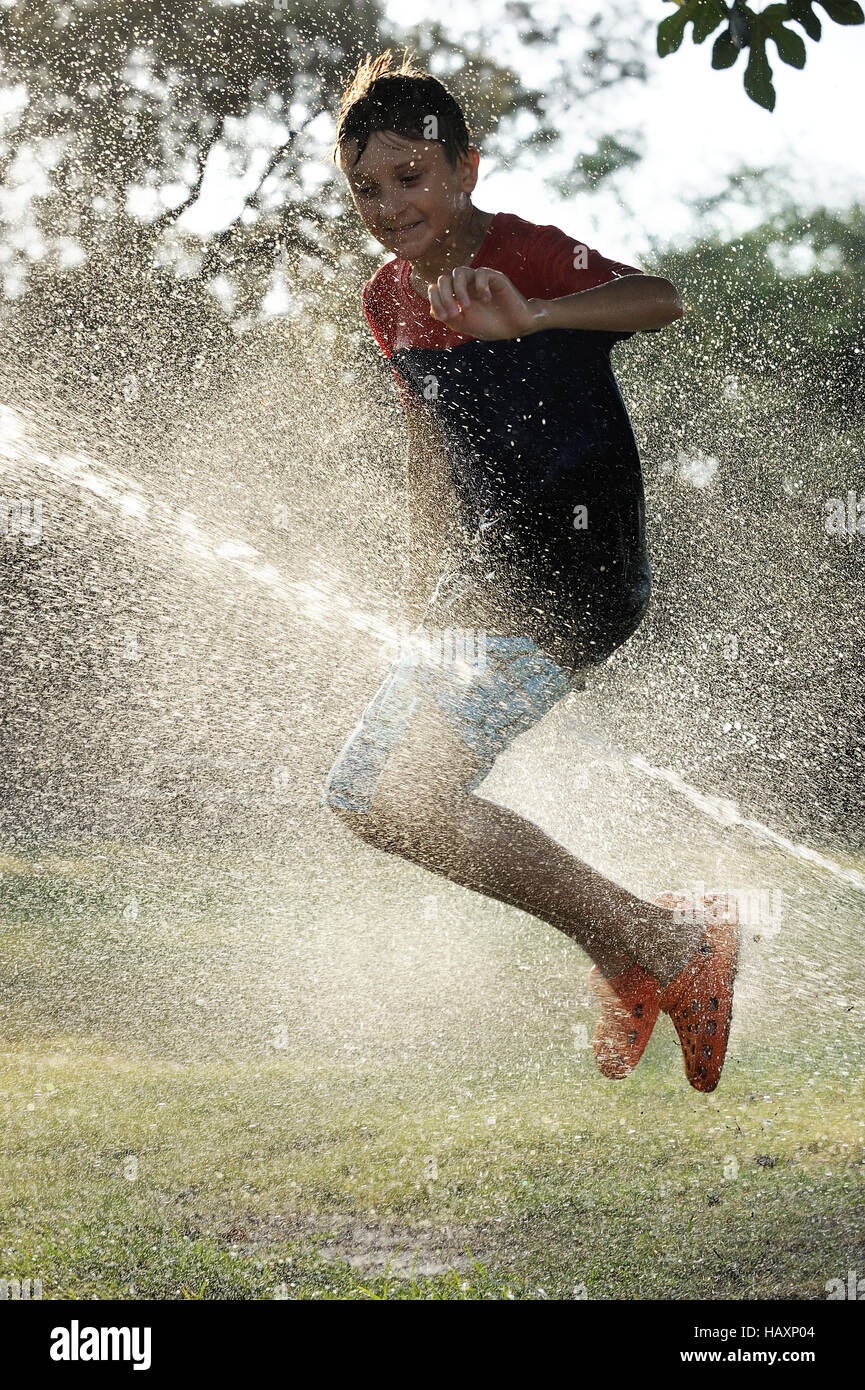 Children play with jets of water in hot weather Stock Photo - Alamy