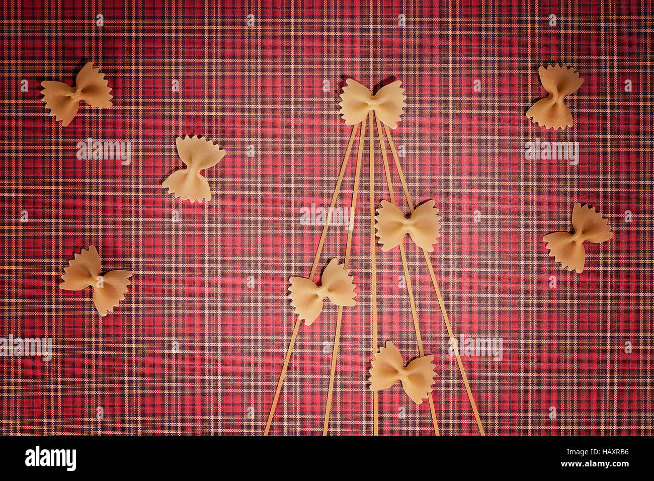 Christmas tree silhouette made of spaghetti and bow tie pasta on red ...