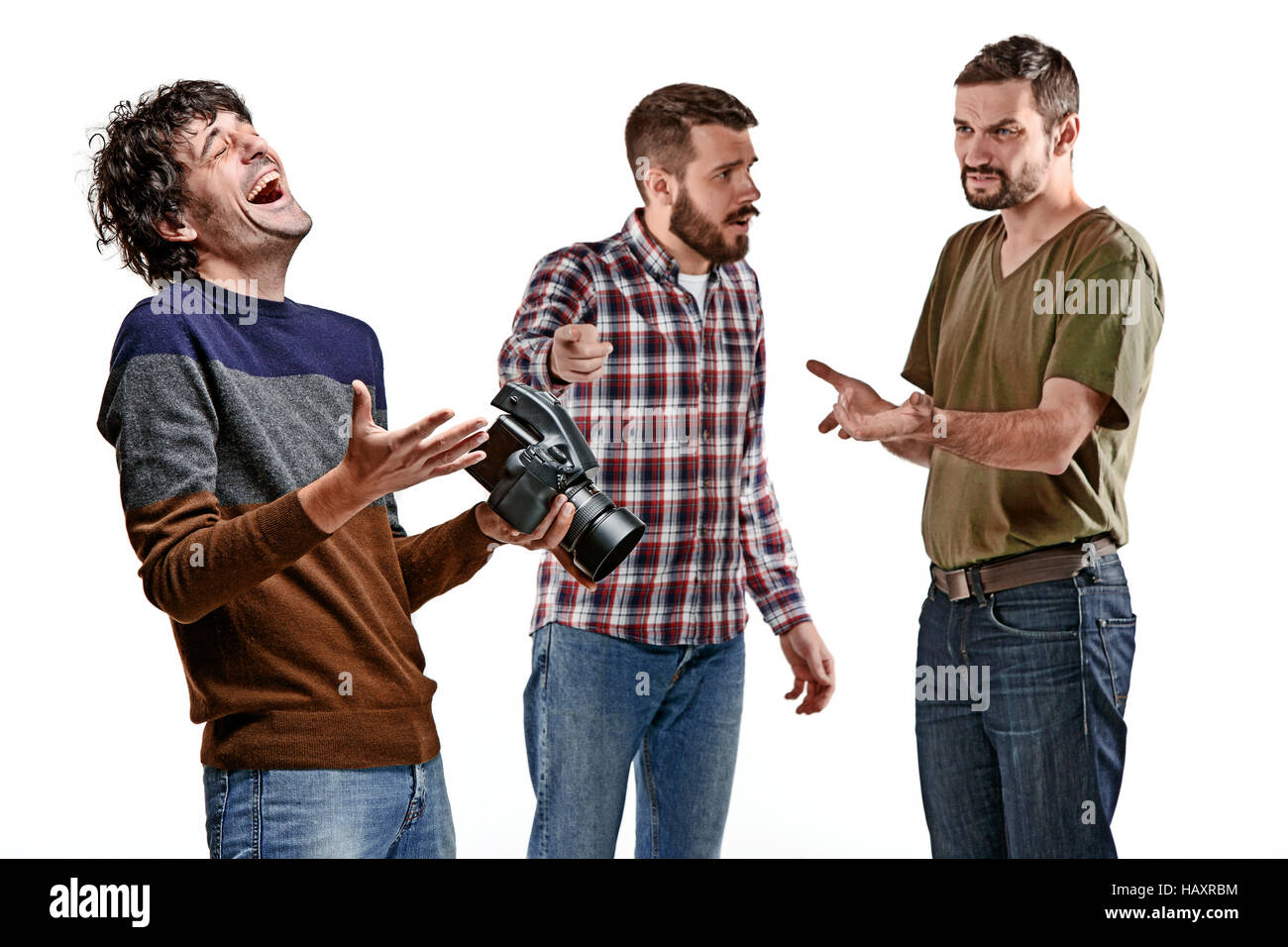The three male friends with camera on white studio background Stock ...